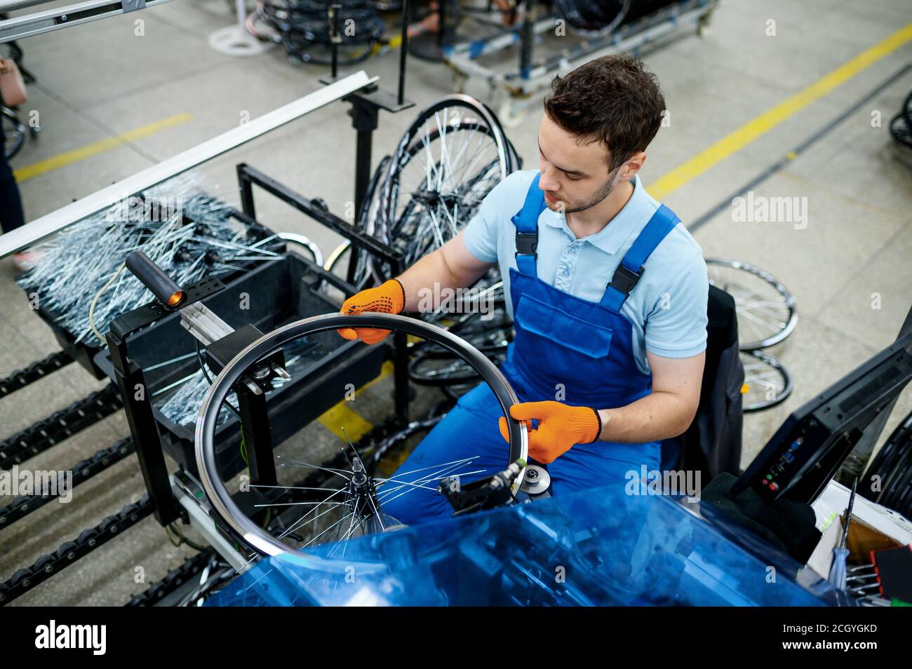 Worker with machine tool installs bicycle spokes Stock Photo - Alamy