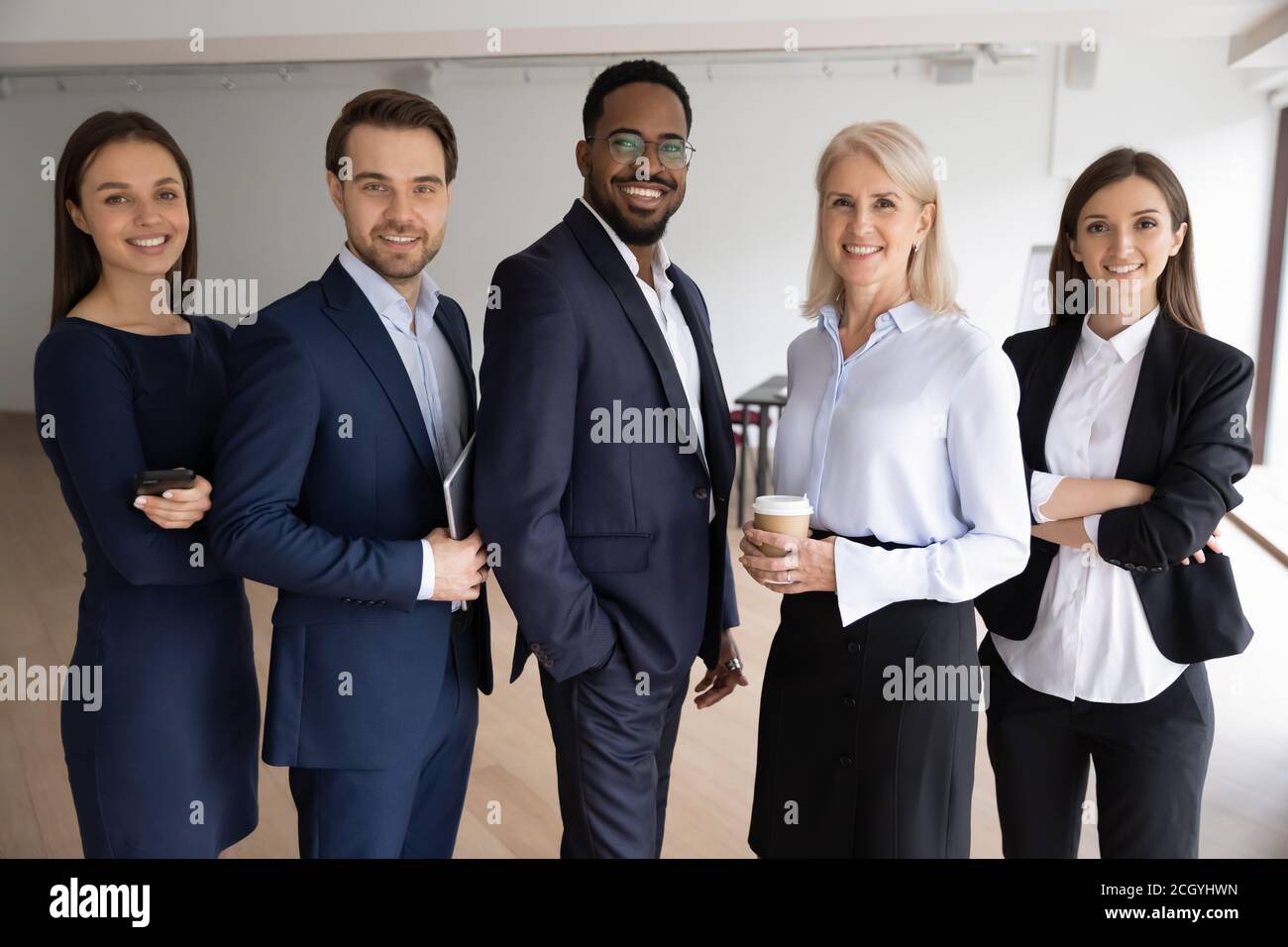 Portrait of smiling multiracial team posing at workplace Stock Photo ...
