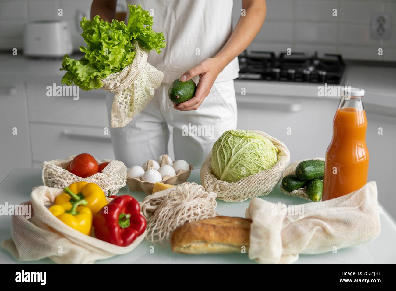 Woman's hand, holding a reusable grocery bag with vegetables on a ...