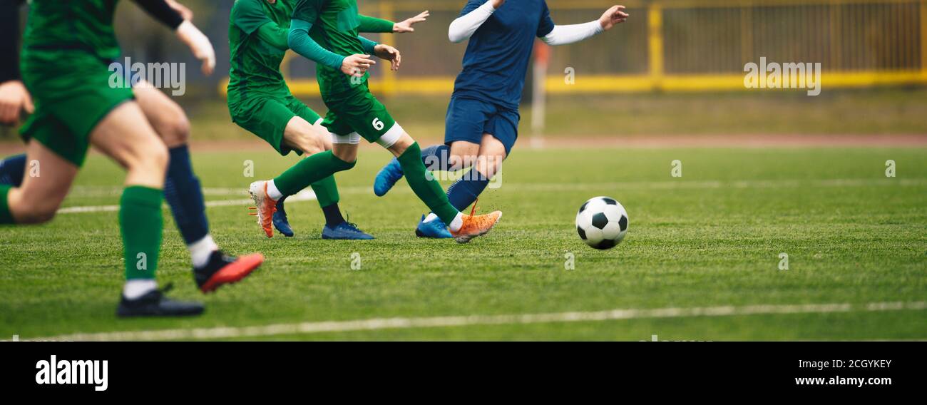Teenagers in soccer duel. Boys in two football teams running after ...