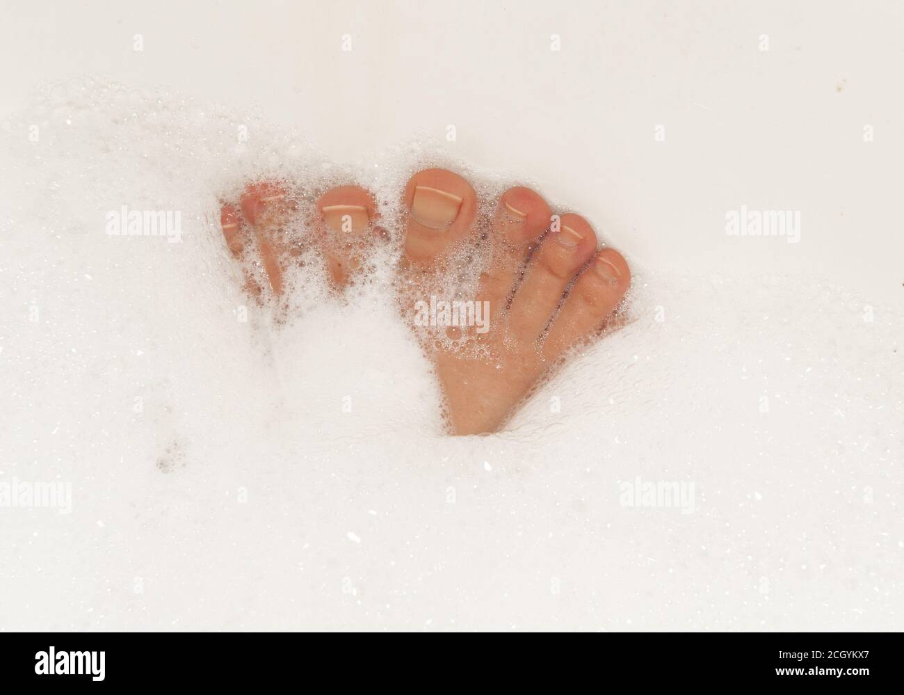 Female feet in soapy foam Stock Photo - Alamy