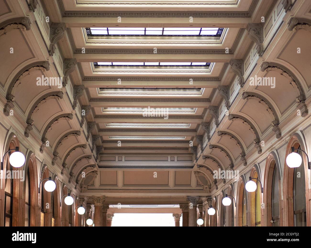 covered walkway illuminated with natural light by a row of skylights on ...