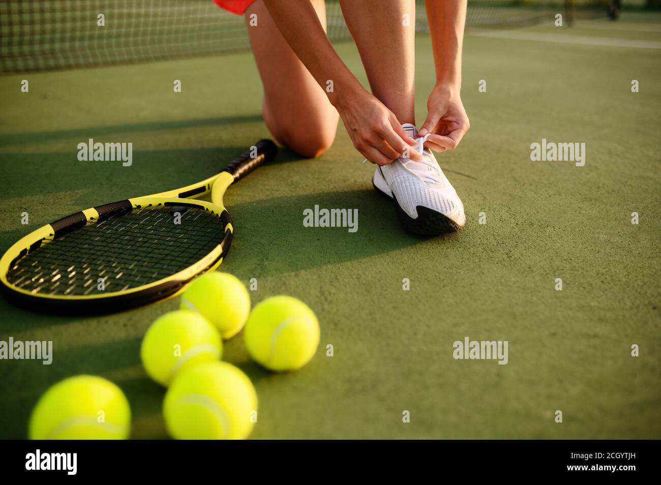 Female tennis player ties her shoelaces Stock Photo - Alamy