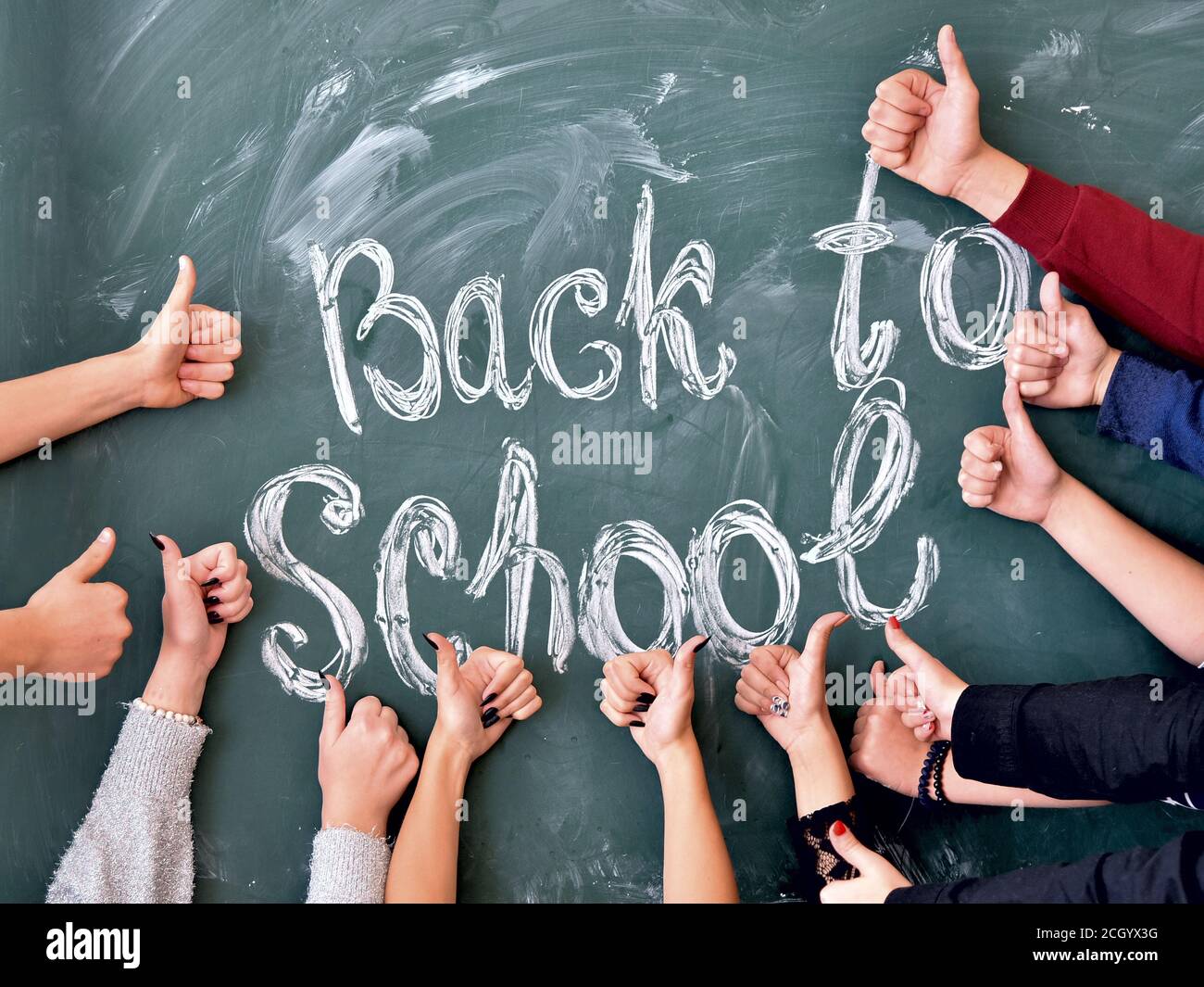 Students hands show thumbs up on the background of the inscription back ...