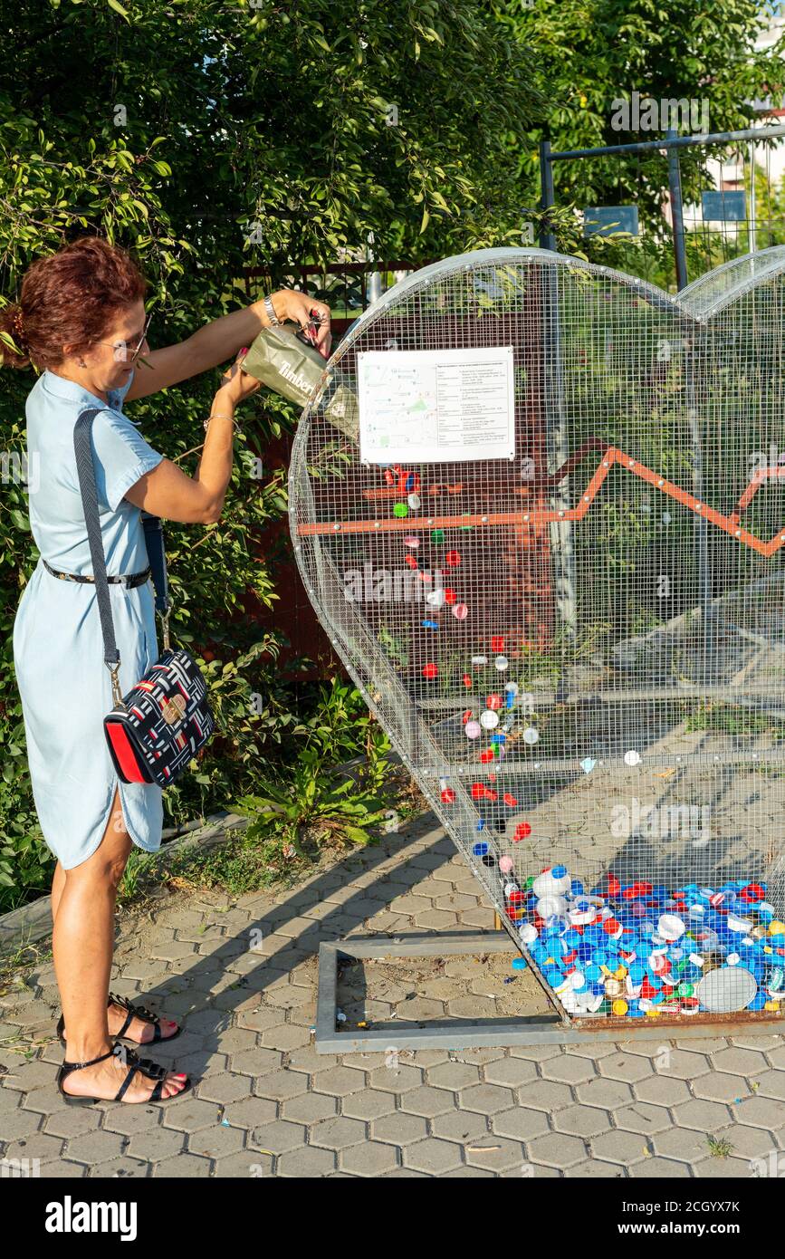 Woman donates used plastic caps at heart shaped recycling bin for the ...