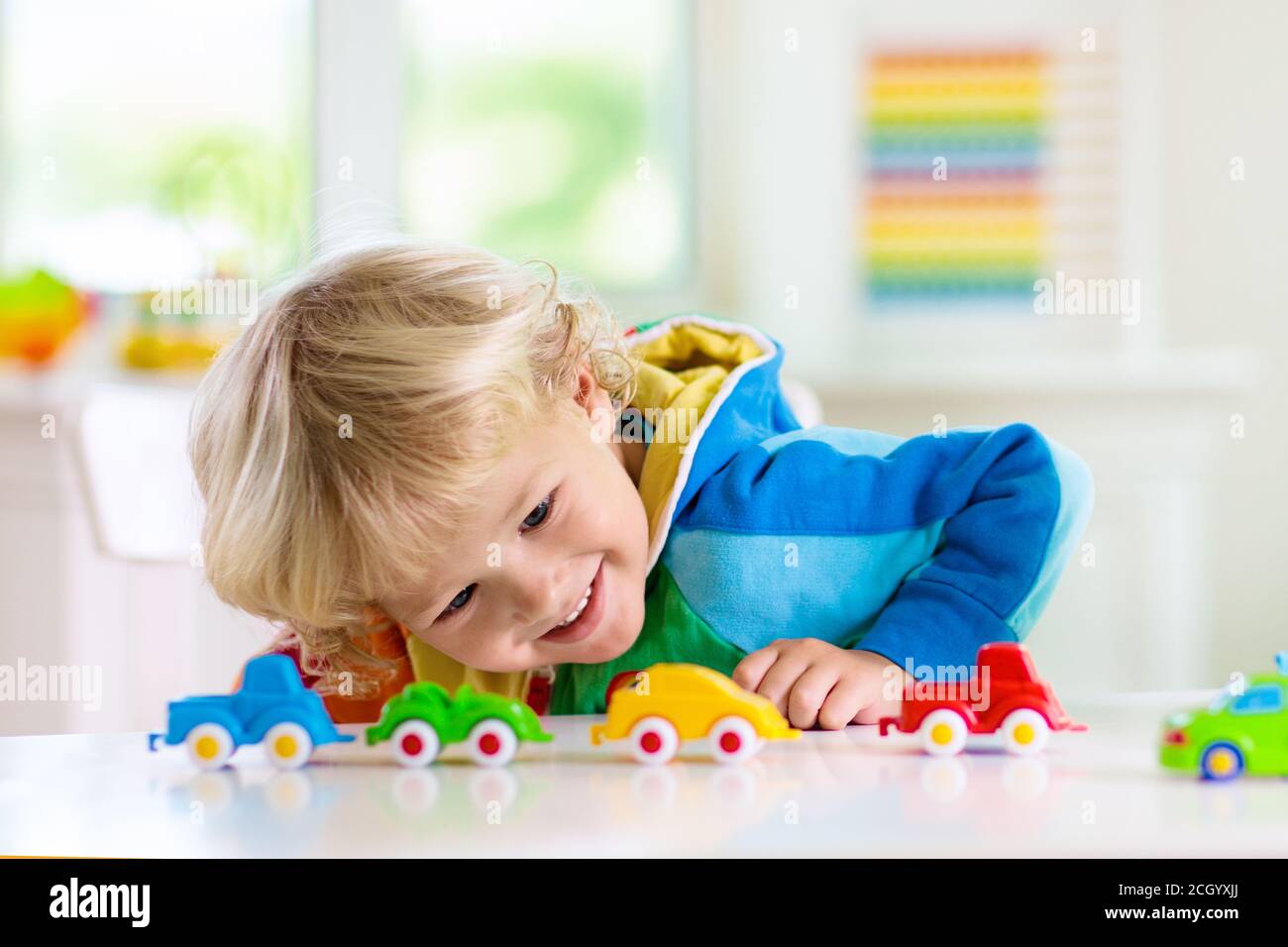 Little boy playing toy cars. Young kid with colorful educational ...