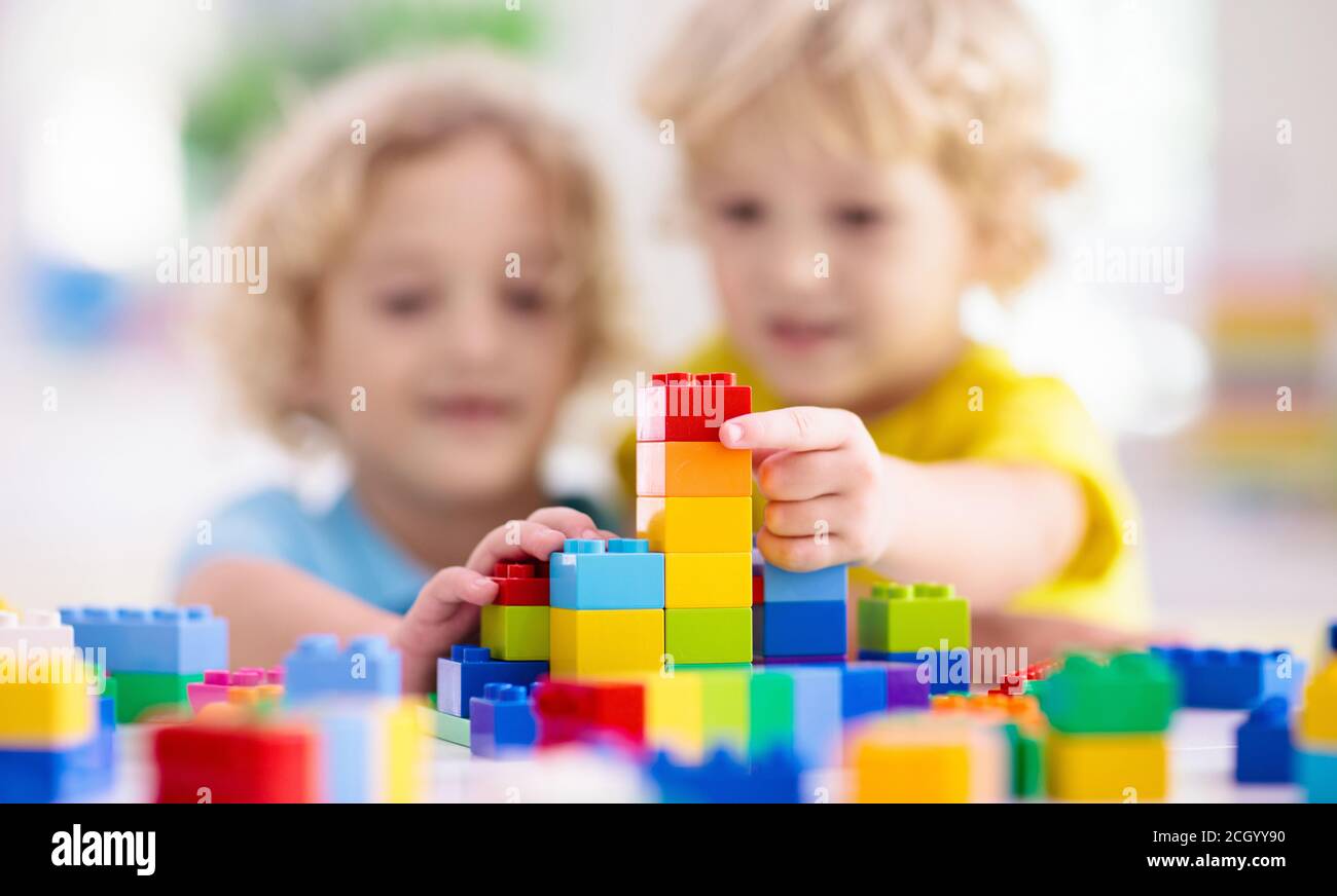 Kids play with colorful blocks. Little boy building tower at home or ...