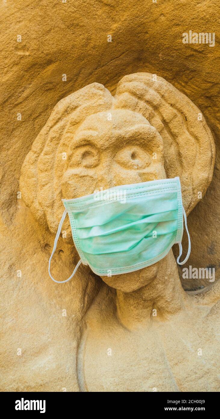 Face sculpted in stone with a mask Stock Photo - Alamy