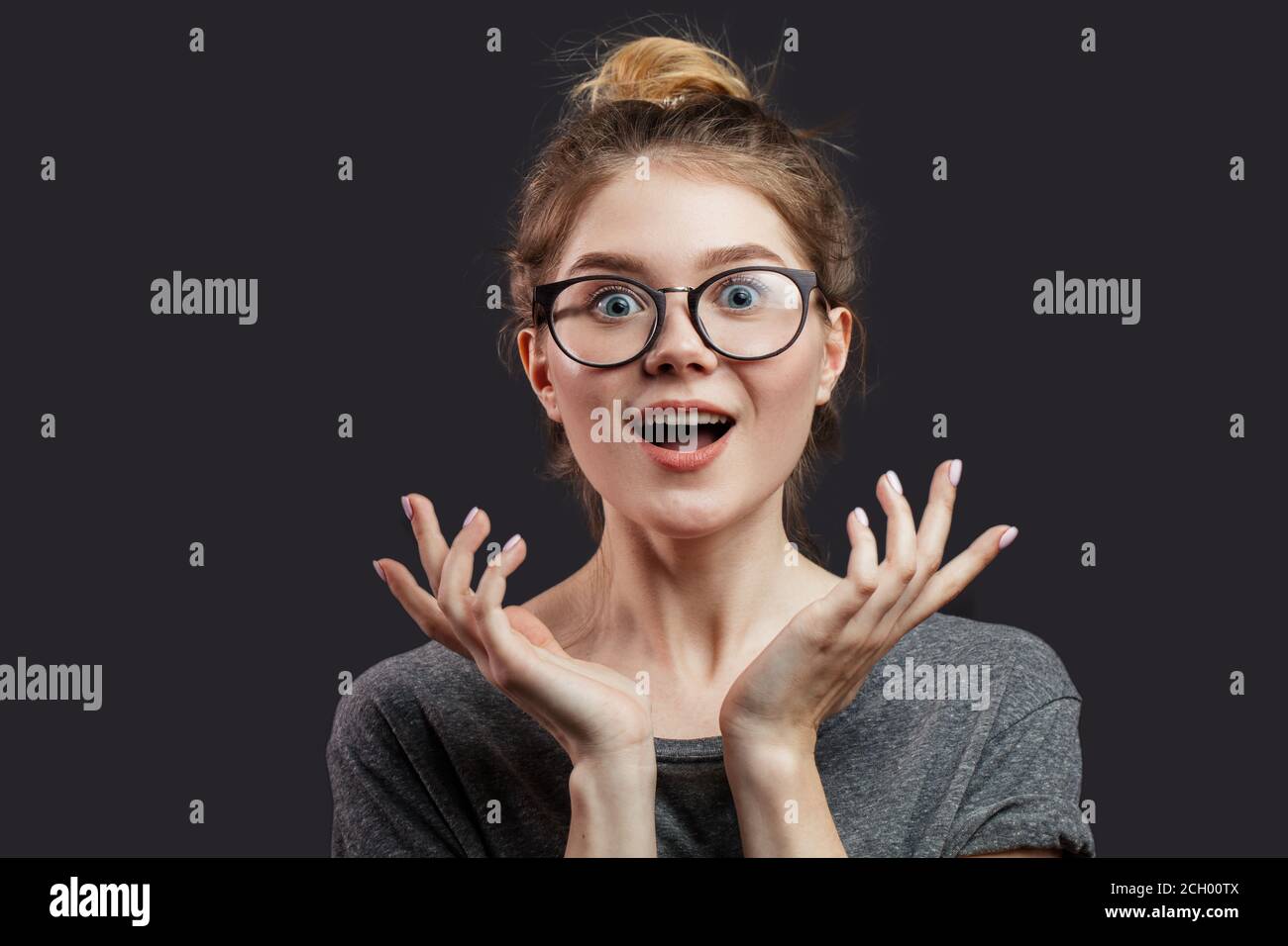 Surprised happy beautiful bug eyed woman looking at camera expresses ...