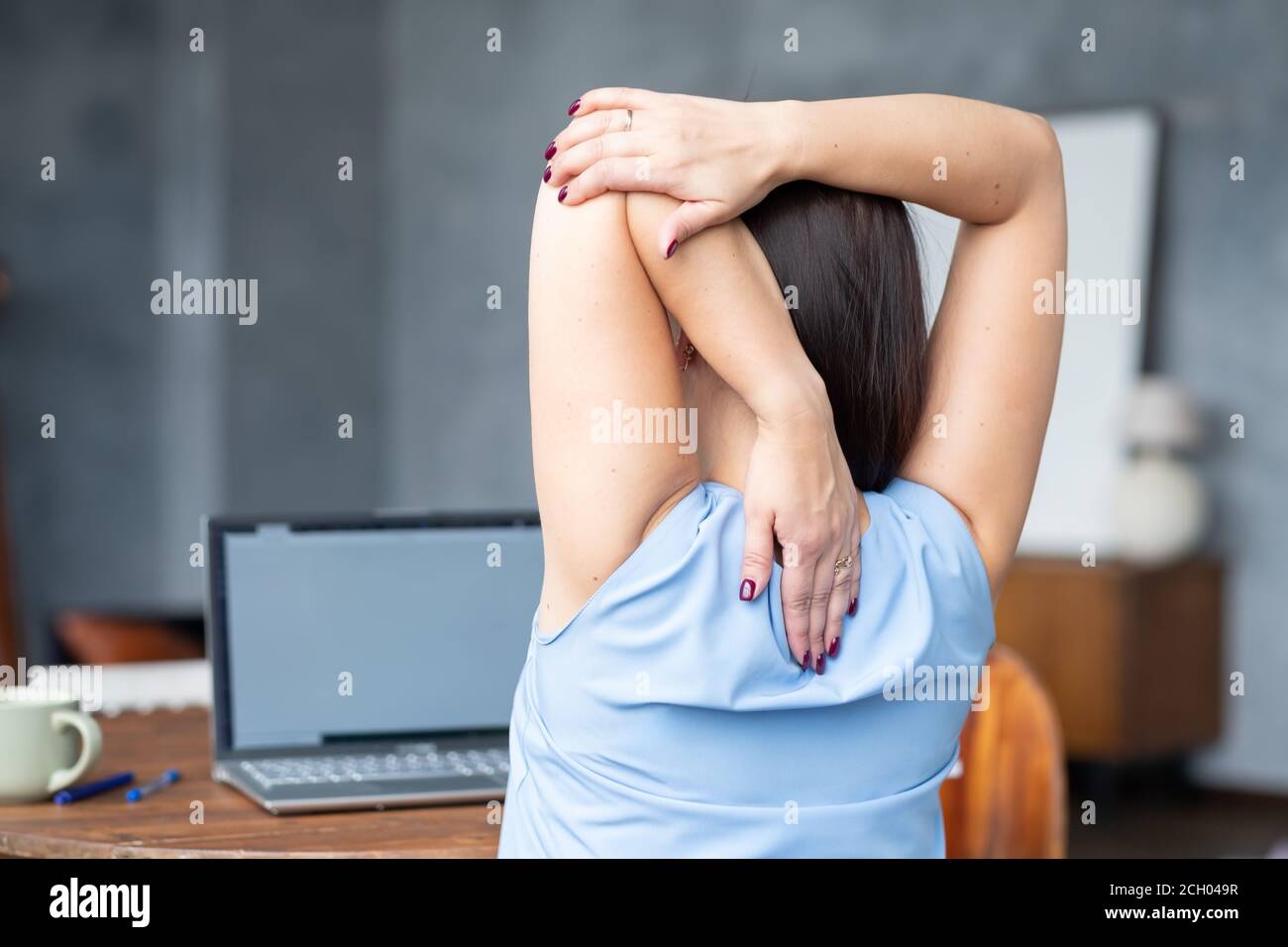 woman stretches her body after hard worling day. Rear view Stock Photo ...