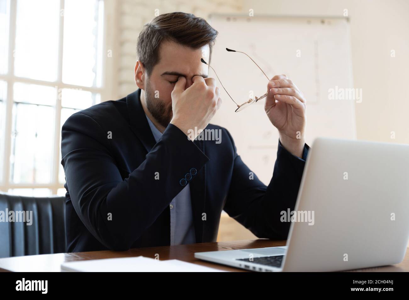 Exhausted male employee take off glasses suffering from headache Stock ...