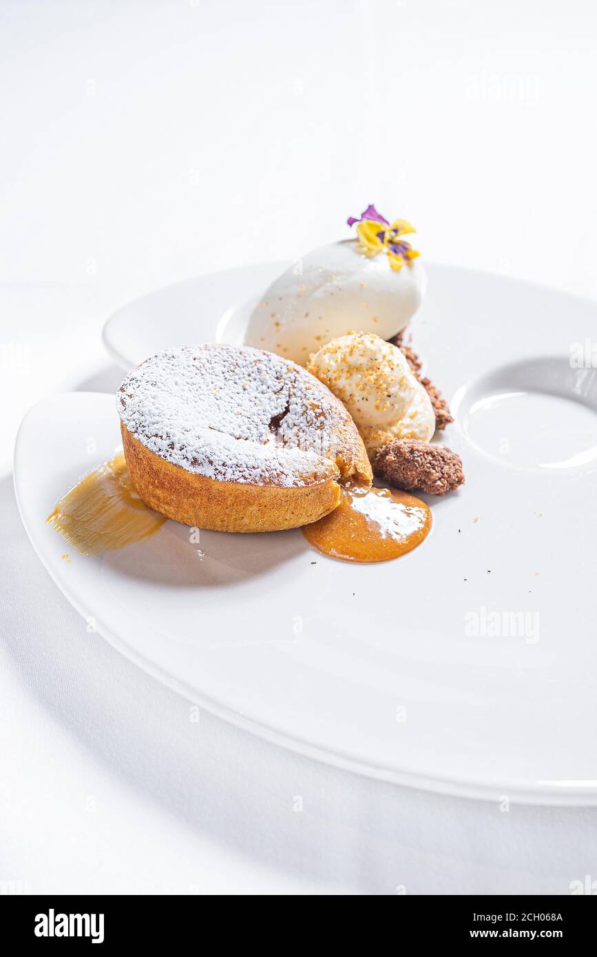 Luxurious dessert with a broken coulant and ice cream on a white ...