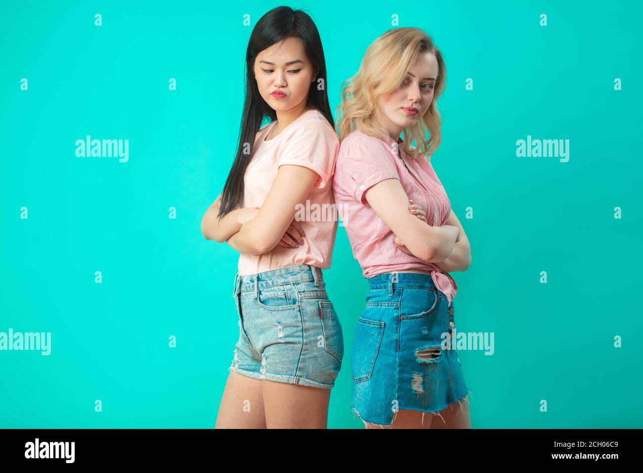 Two multiethnic teenage girls being in quarell, not speaking with each ...