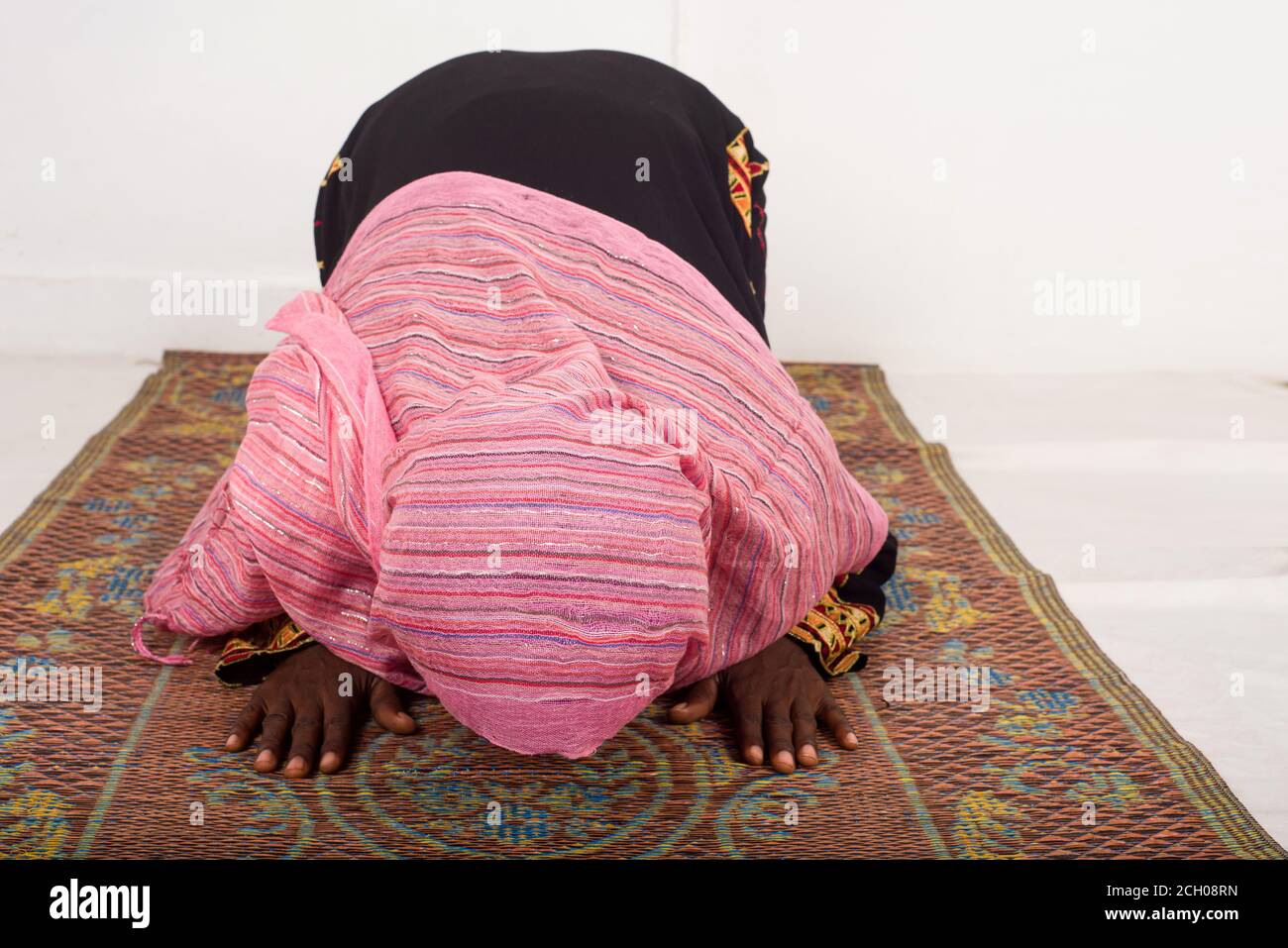 Muslim woman with her forehead on the ground praying in the mosque ...