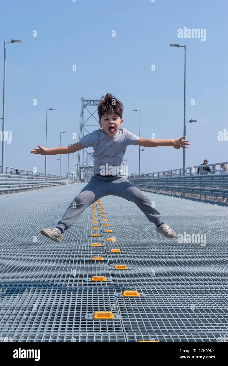 Isolated. Boy jumping with arms and legs open. Happy little boy ...