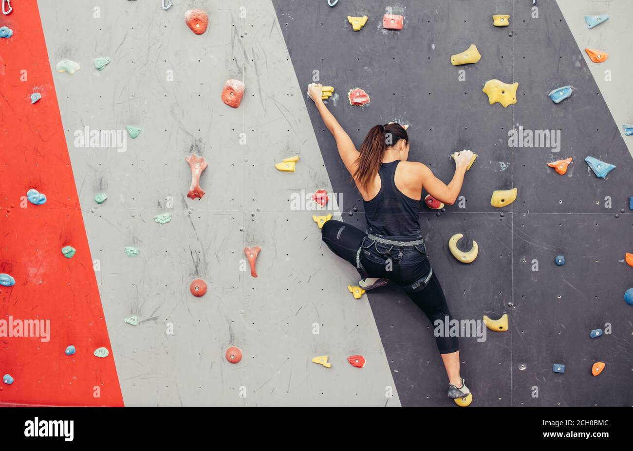 Back view of professional climber unrecognizable woman climbing on ...