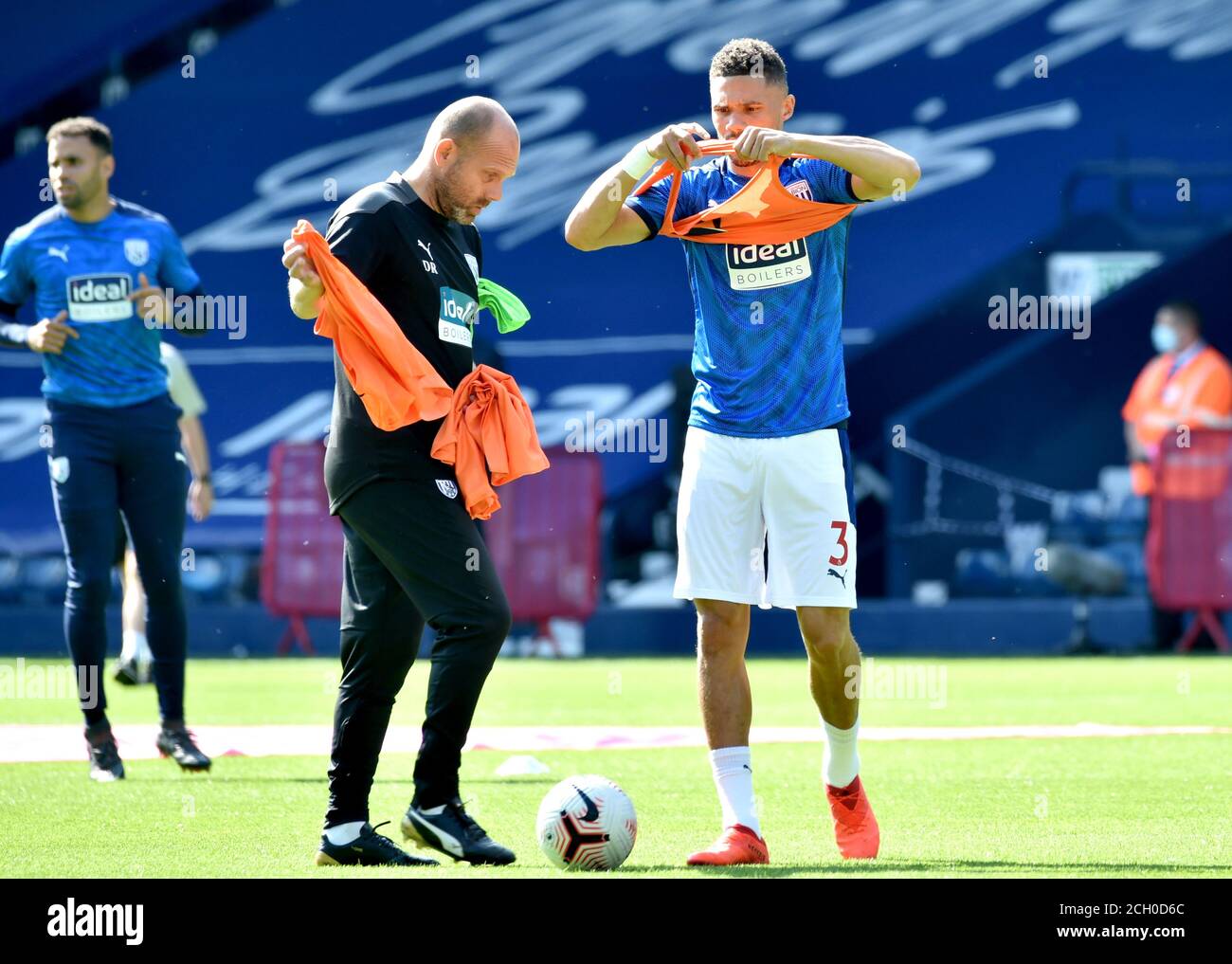 West Bromwich Albion's Kieran Gibbs (right) puts on a bib as he warms ...