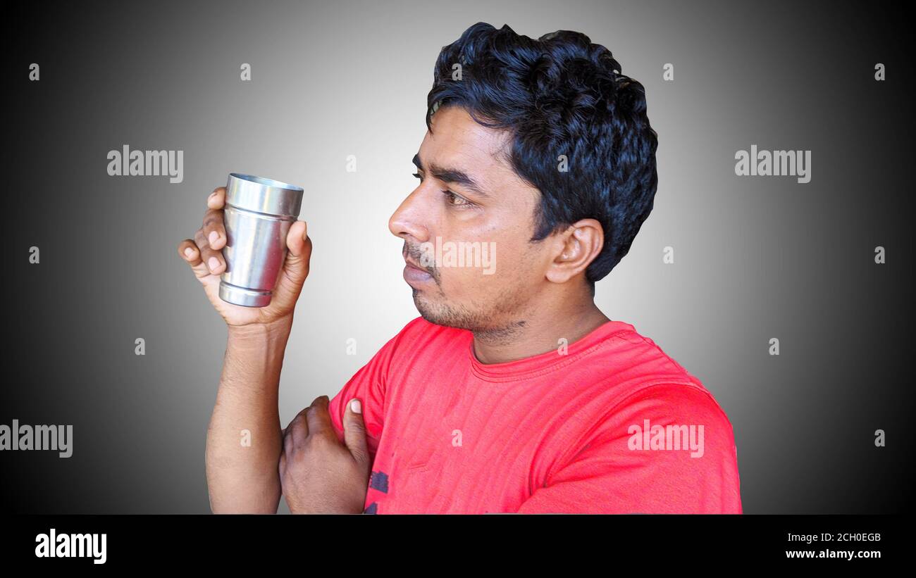 A Man sitting on a chair and drinking tea at home. Indian young man ...
