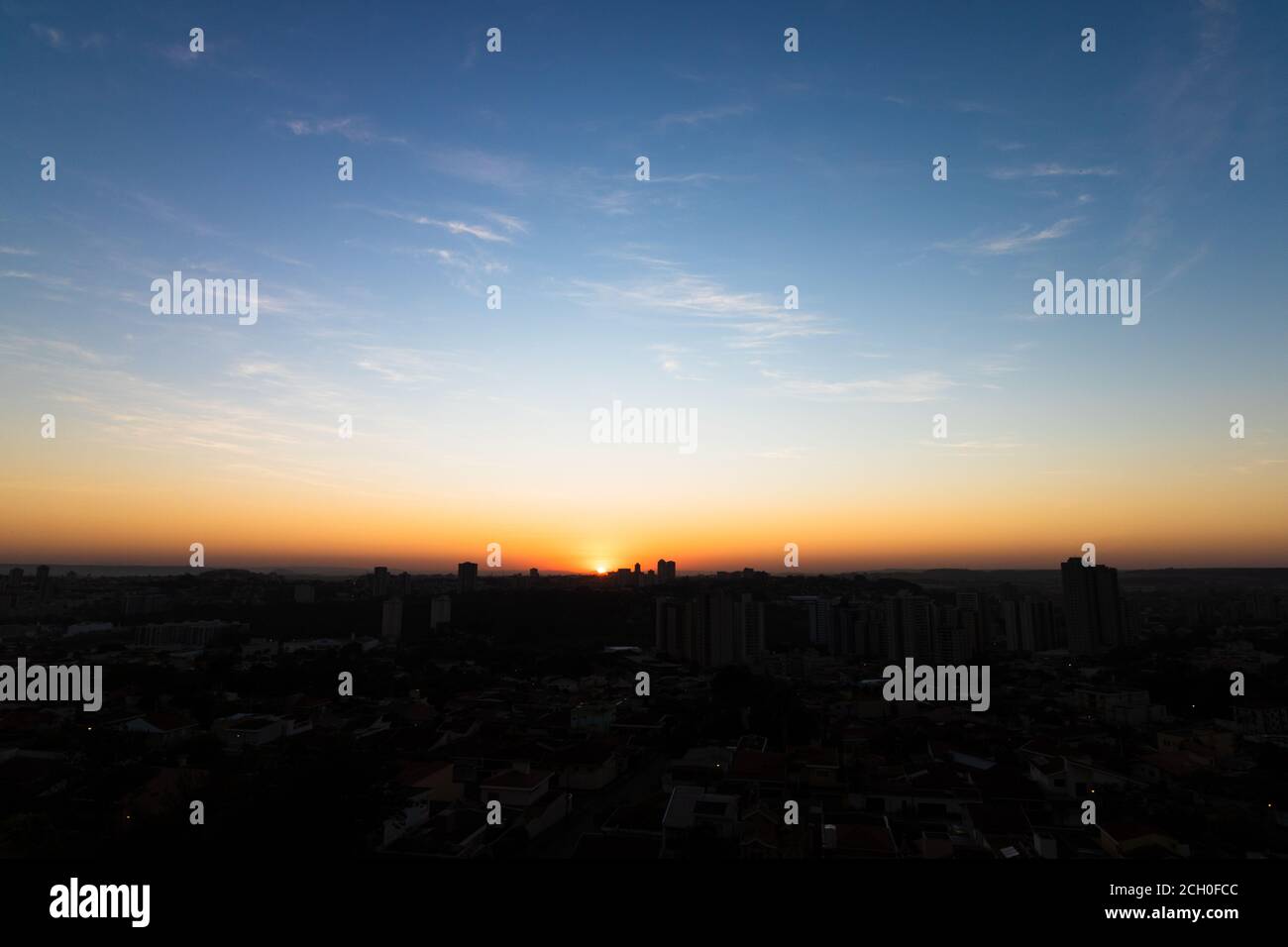Rising sun with silhouette of buildings on city skyline Stock Photo - Alamy