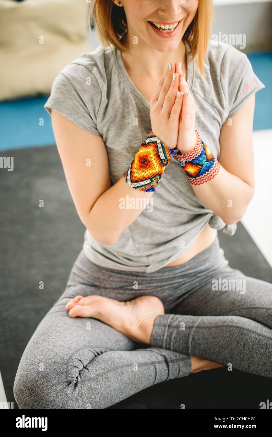 Cropped view of young woman in lotus pose with hands clasped in ...