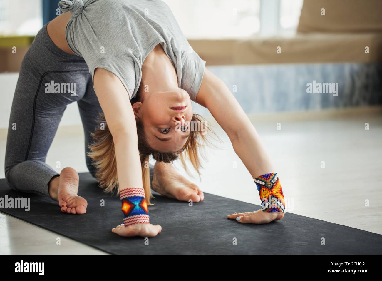 Flexible women in yoga bridge stance exercising in Urdhva Dhanurasana ...