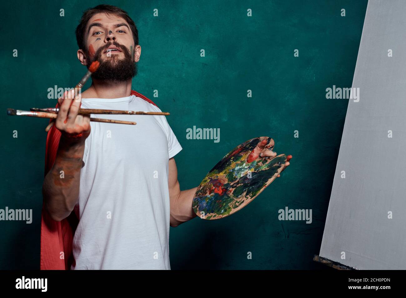 Male artist red cloak drawing easel art green background image Stock ...