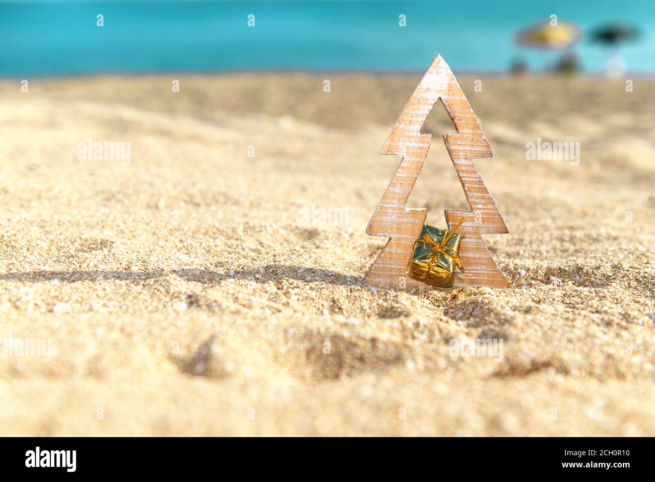 Timber wooden Christmas tree on a sand on the tropical beach near ocean ...