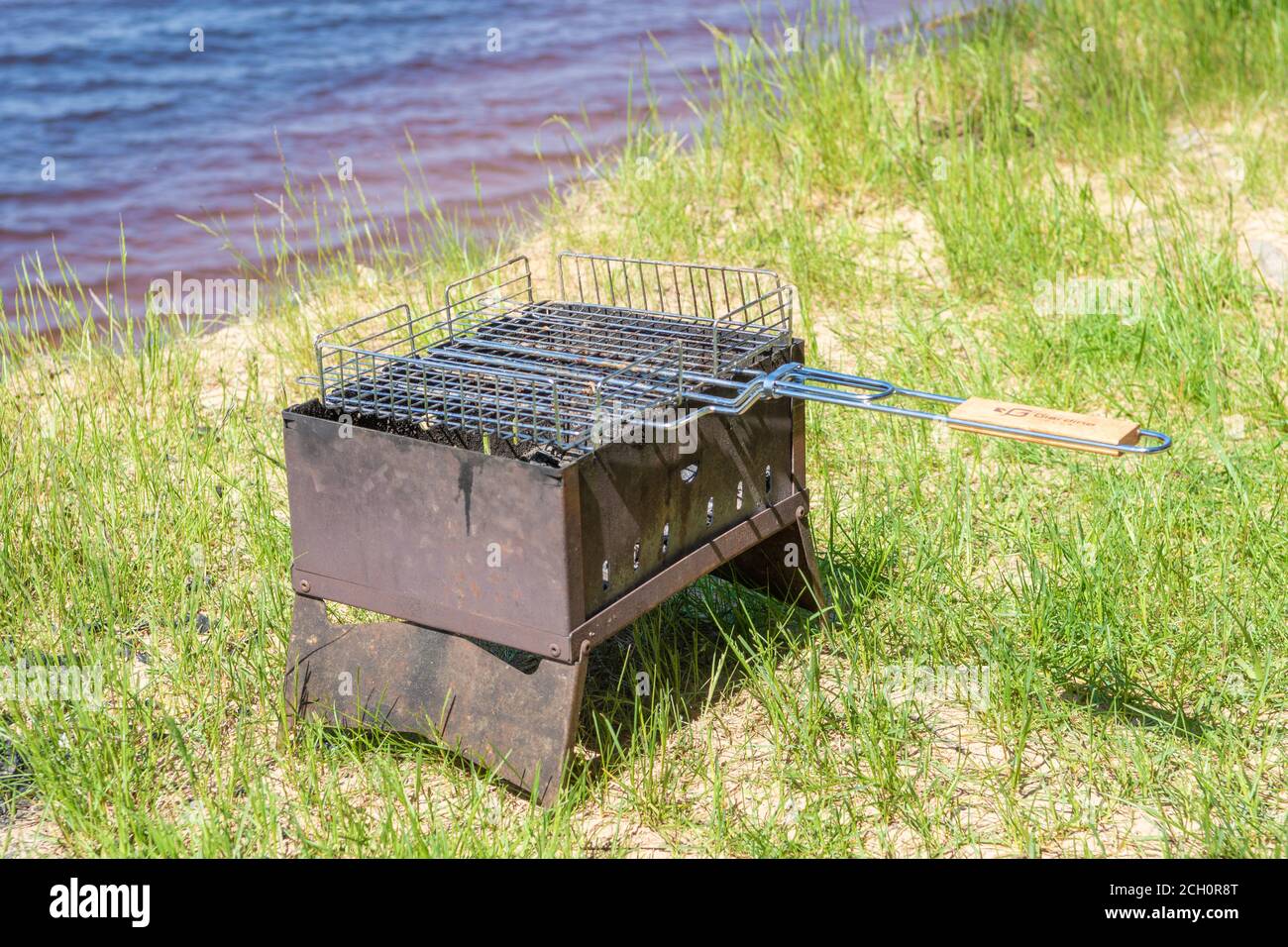 little BBQ grill on the lake, rest at nature Stock Photo - Alamy