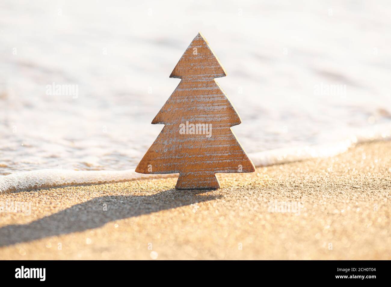 Timber wooden Christmas tree on a sand on the tropical beach near ocean ...