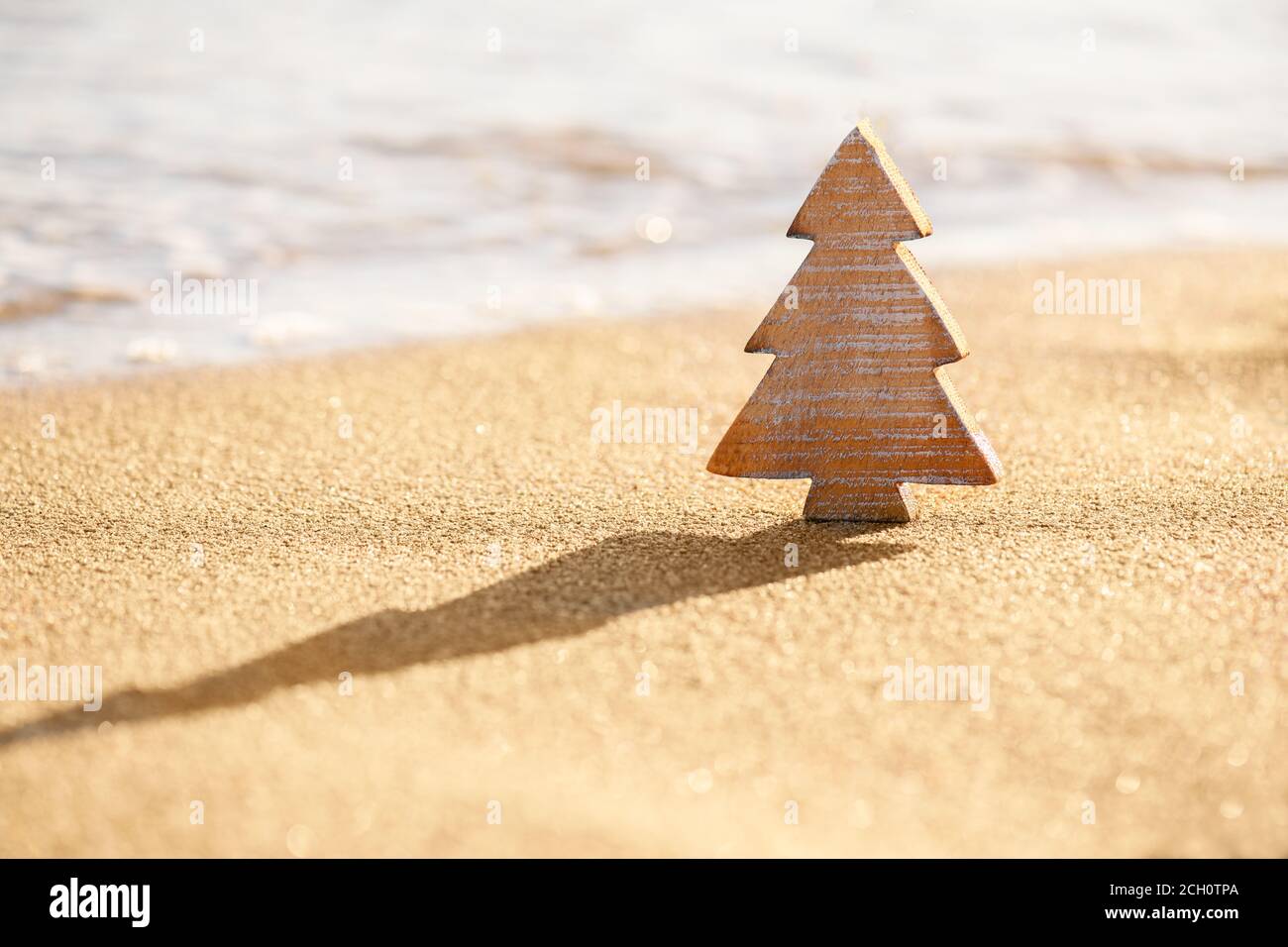 Timber wooden Christmas tree on a sand on the tropical beach near ocean ...