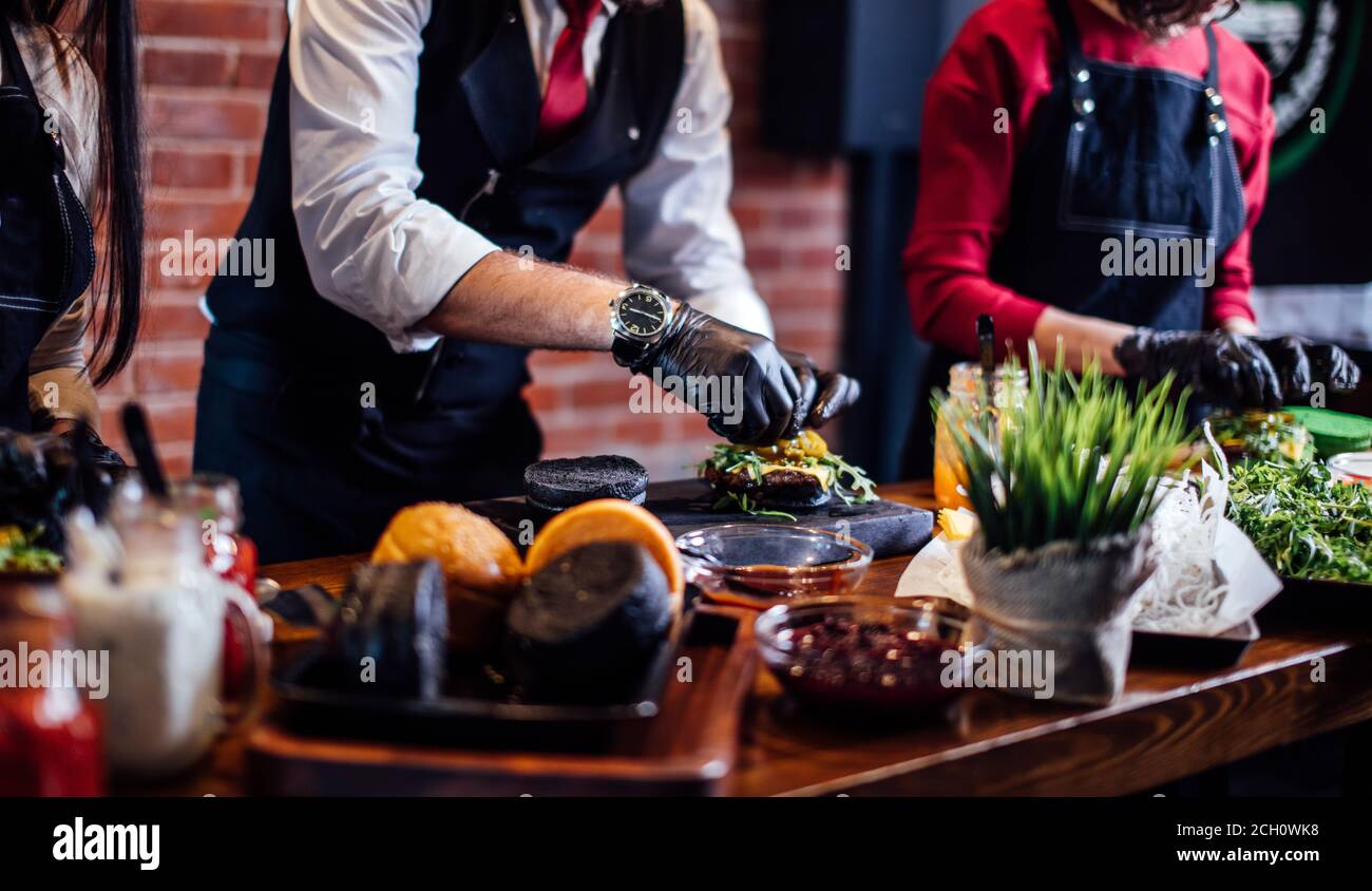 Chef making beef burgers indoor at restaurant kitchen, participating in ...
