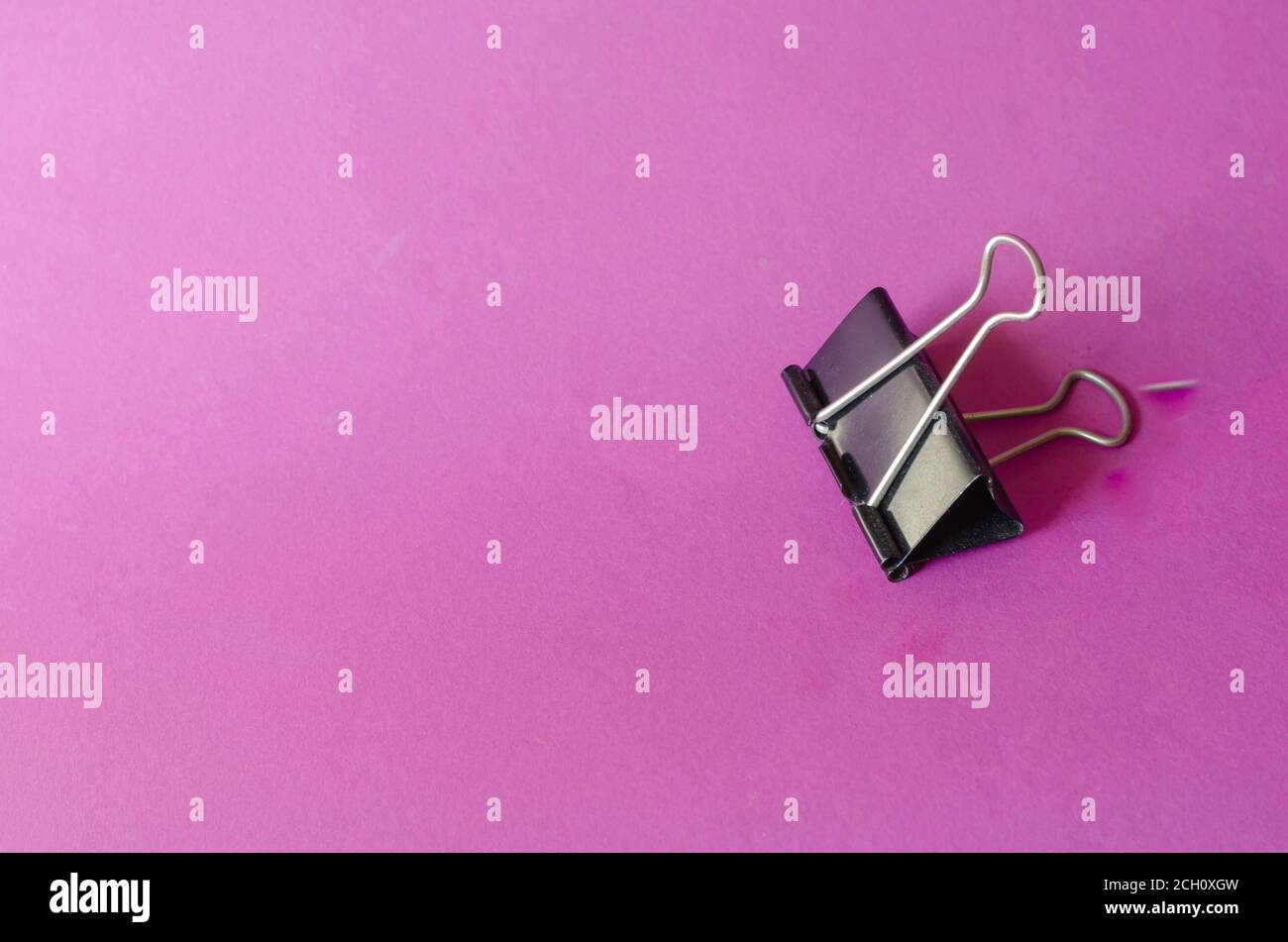 Metal black Binder Clips on a pink background. Single clamp for papers ...