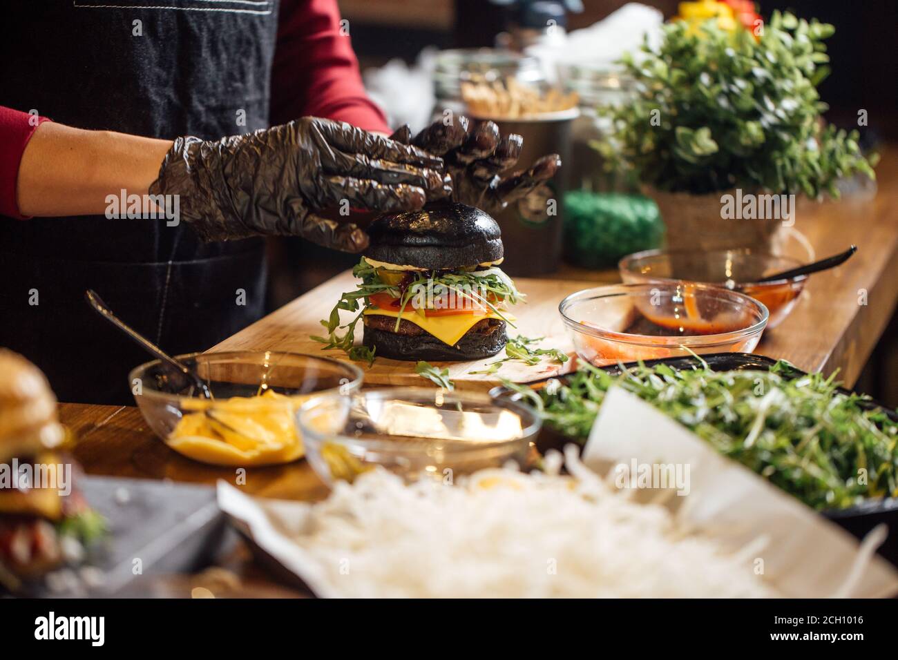 Process of cooking burgers. Cropeed view of chef hands in black gloves ...