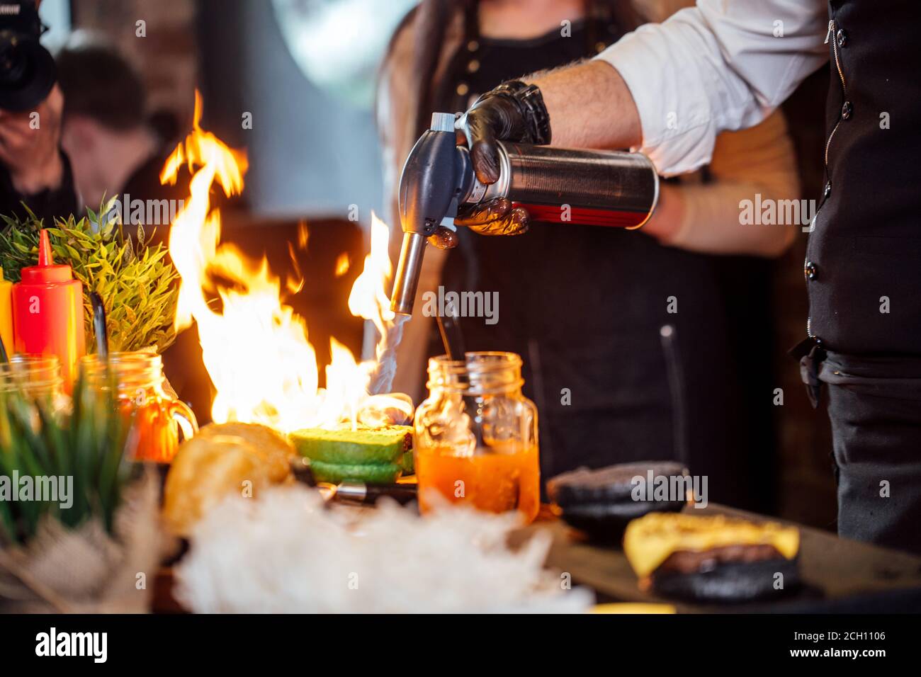 Chef making beef burgers indoor at restaurant kitchen, participating in ...