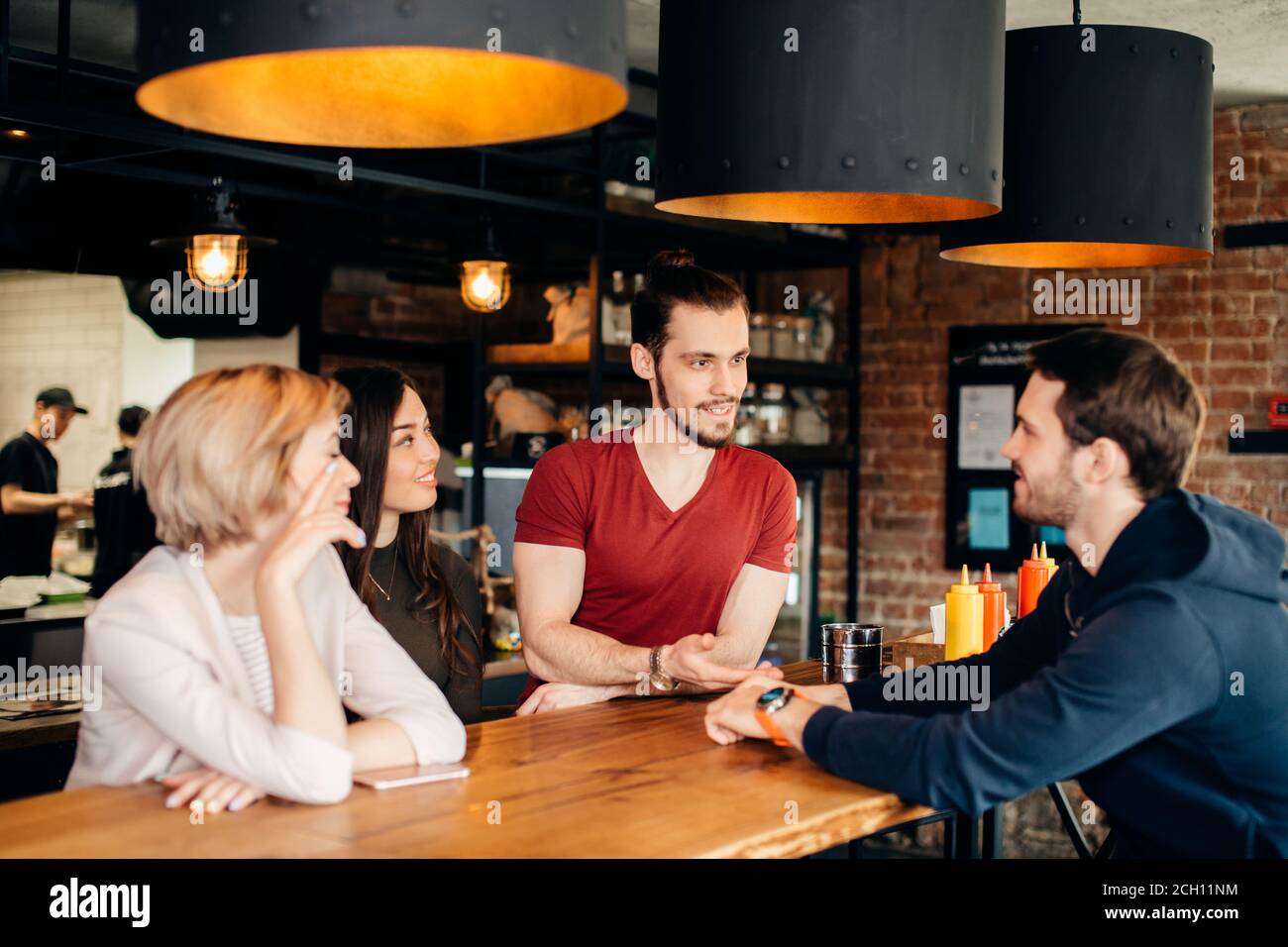 Group of four friends discussing their future plans together. Two women ...