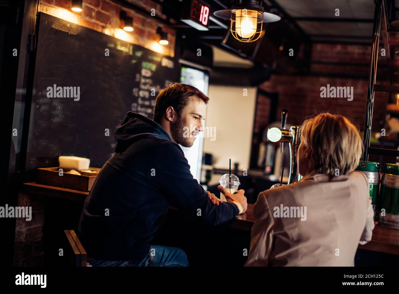 Back view of young couple enjoying romantic moments while talking in a ...