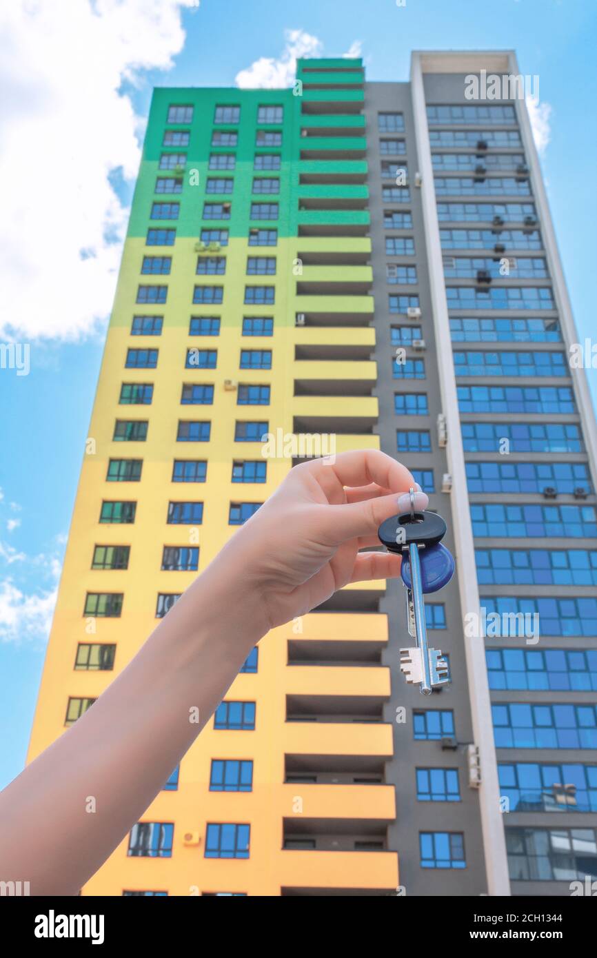 Hand with keys in the background apartment building. Real estate ...