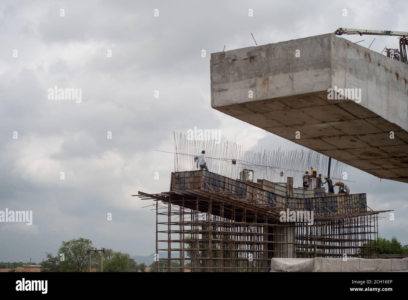 Labor and workers standing on a support for a bridge under construction ...
