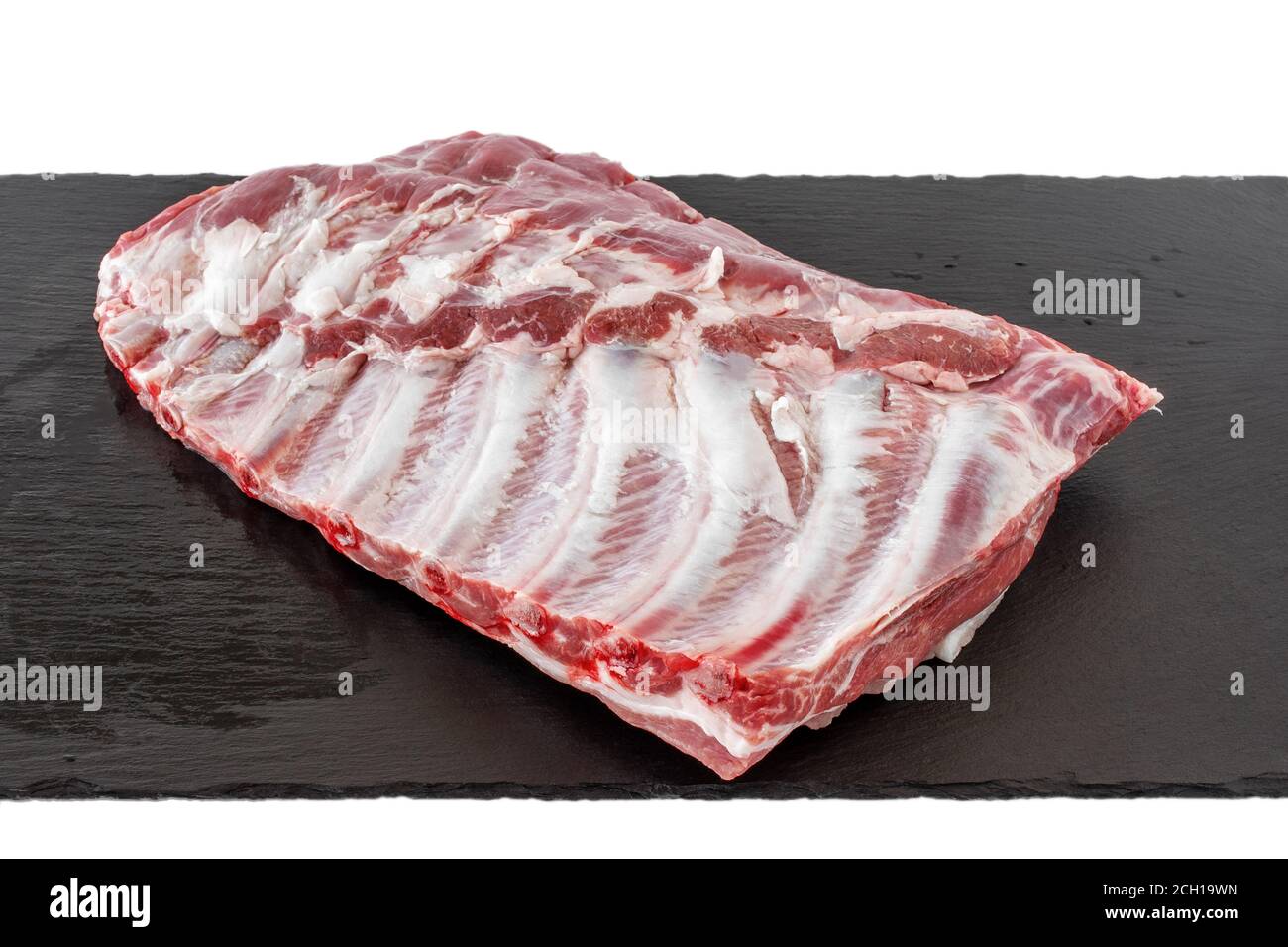 raw pork ribs isolated on dark, black, stone board. spare ribs or belly ...