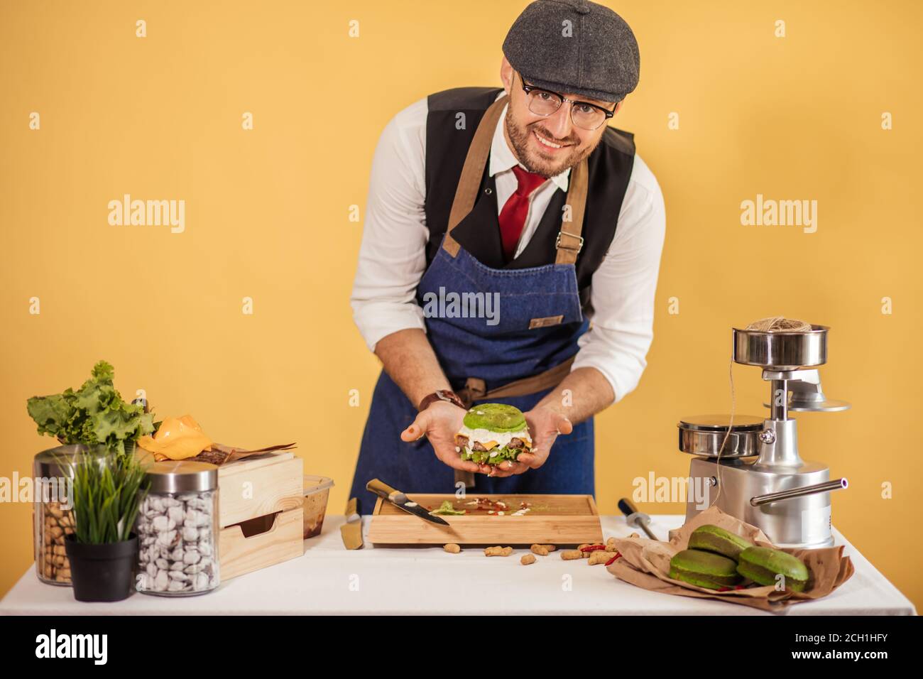 The caucasian Chef wearing creative cap and blue apron demonstrating ...