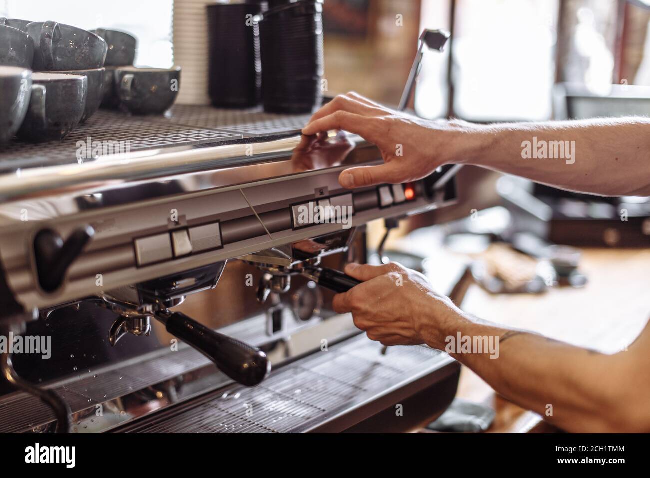 a male is turning the coffee machine off. close up side view cropped ...