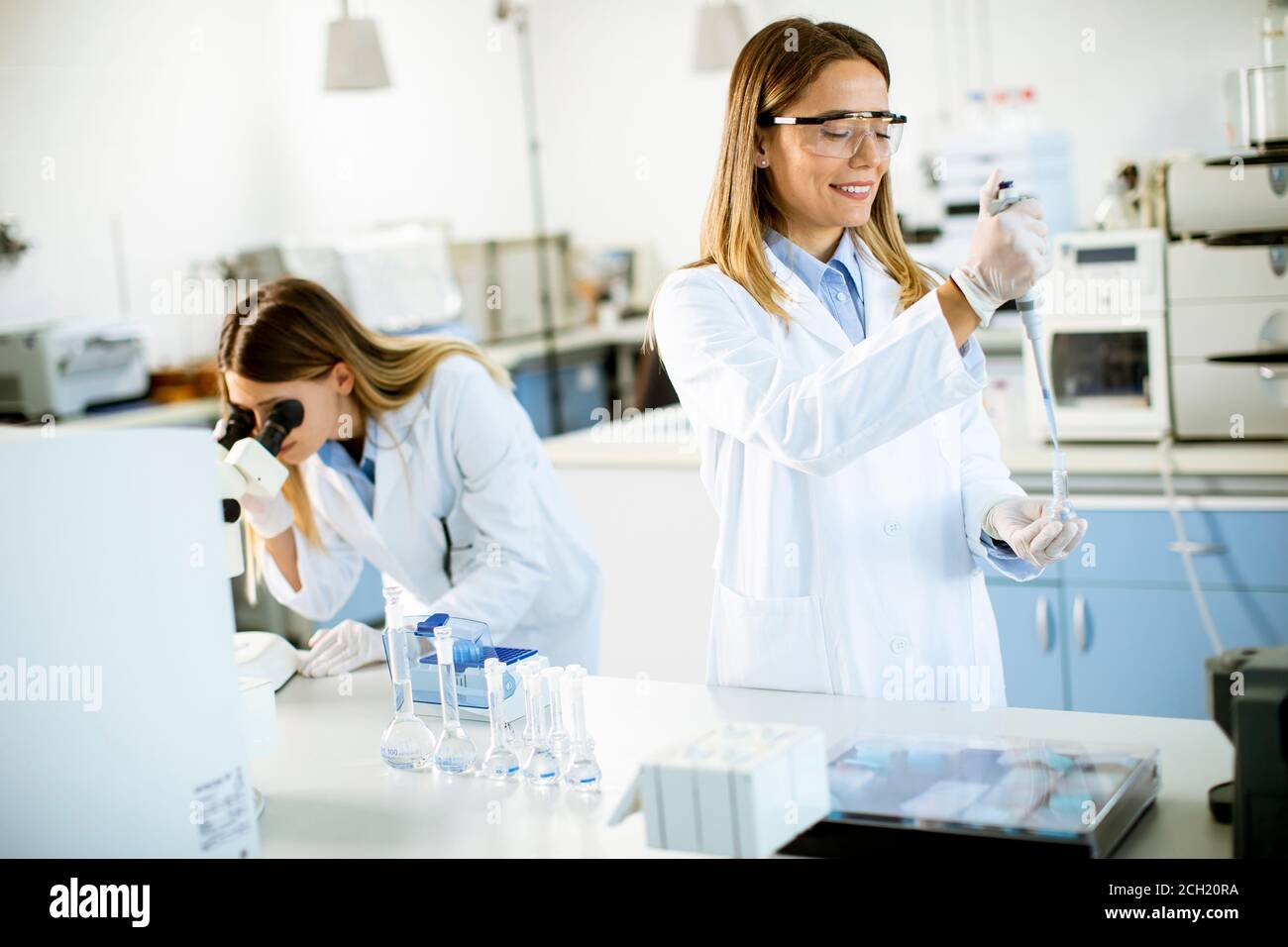 Cute female researchers in white lab coat working in the laboratory ...