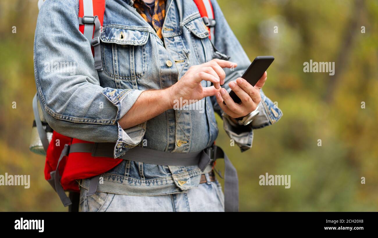 Close up male hiker hands using mobile phone. Man taking help of mobile ...