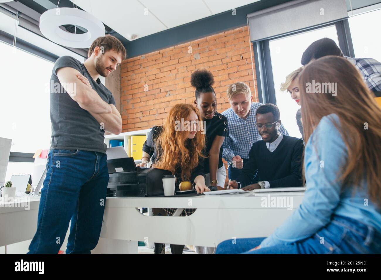 curious workers looking at their African boss's documents in the office ...