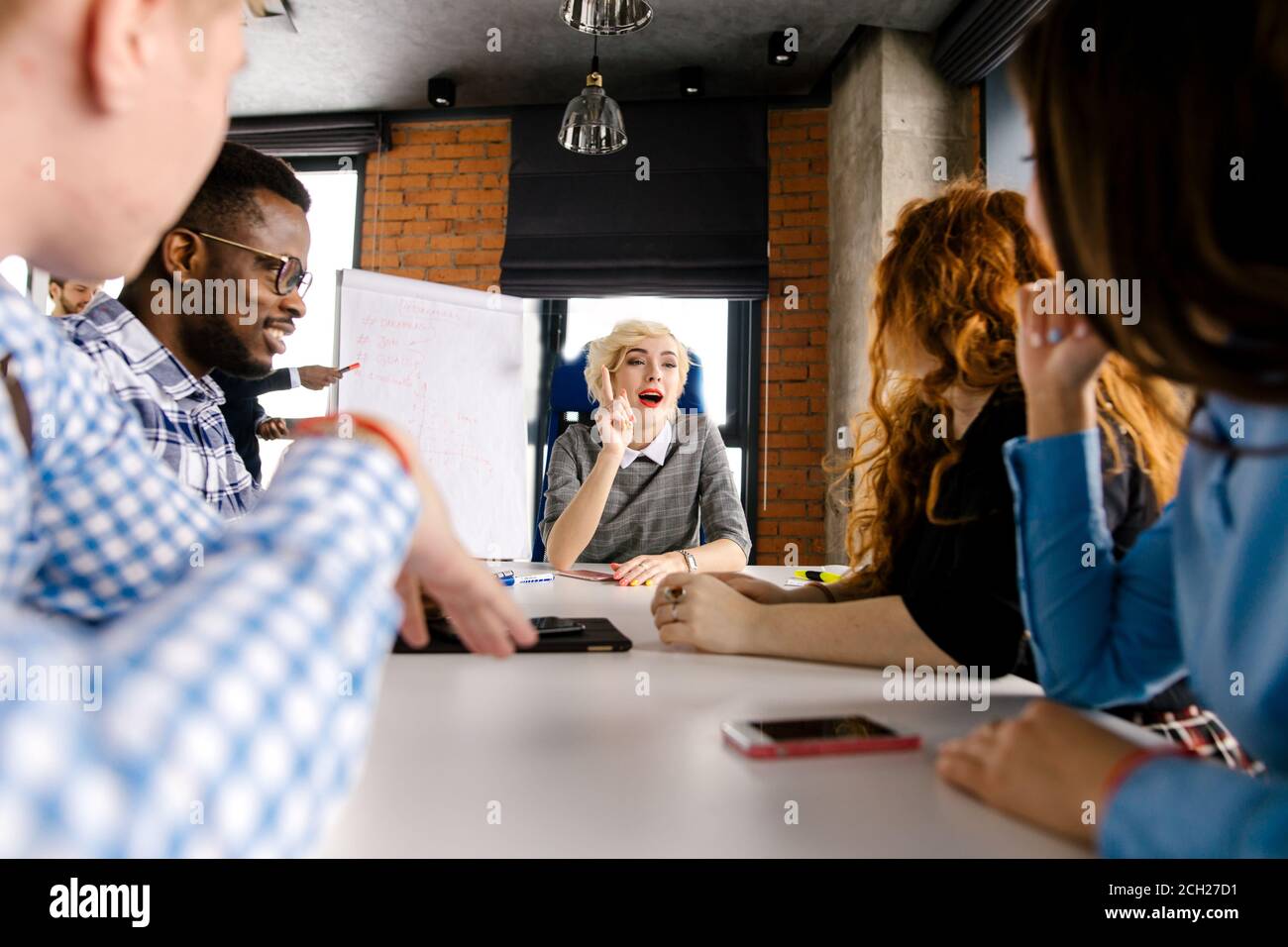 Team blond leader instructing staff sitting around the desk Stock Photo ...