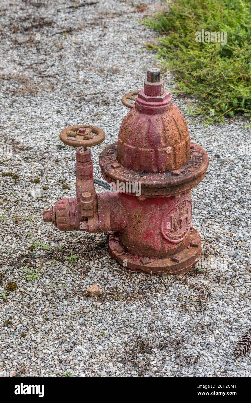 Old red fire hydrant partially in the ground with several layers of ...