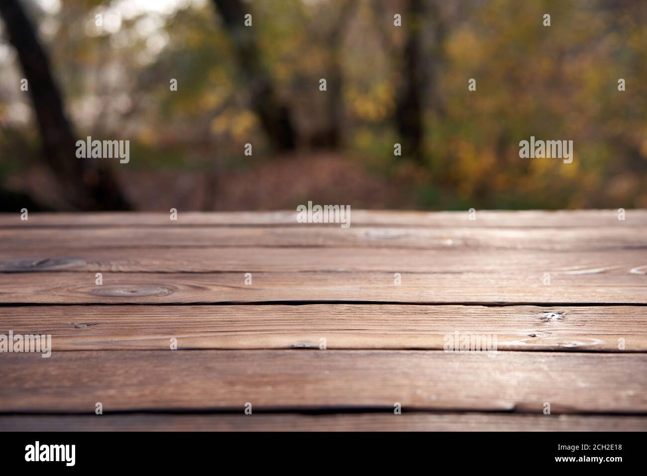 Empty wooden table autumn nature bokeh background with a country ...