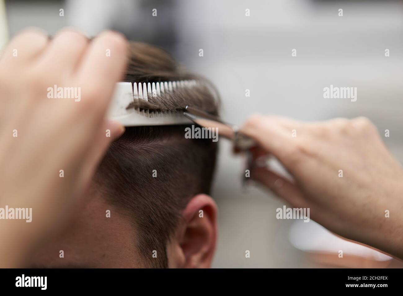 Beautiful caucasian woman hairdresser doing hairstyle to client. Close ...