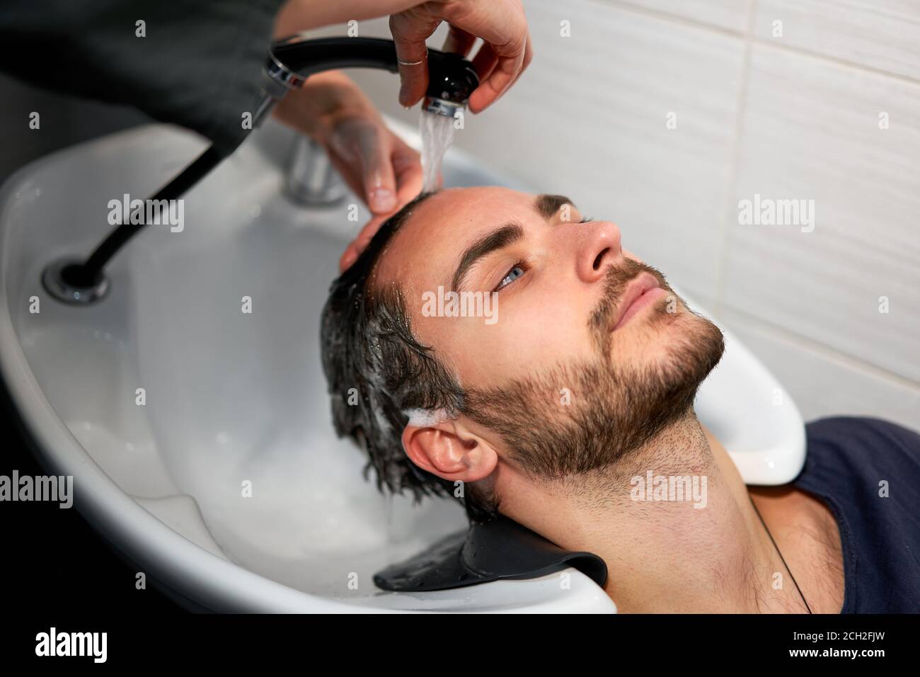 Woman applying shampoo massaging hair customer Man wash hair in beauty ...