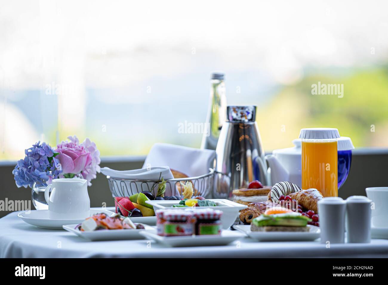 plates with assorted breakfast meal on a white table in a hotel room ...